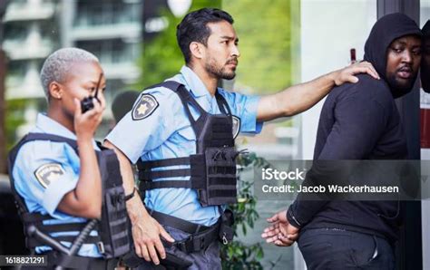 경찰 체포 및 범죄 야외 권력 투쟁 범죄 및 워키 토키로 사법 및 법률 경찰관 거리의 용의자 또는 남자 시내 감옥 또는 서비스와 함께 전문 법 집행 기관 경찰관에 대한 스톡