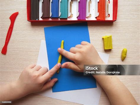 아이는 Plasticine에서 인물을 연주하고 조각합니다 유색 플라스틱을 가진 아이들의 손 휴가 중 어린이 게임과 창의력 어린이의 손가락 미세 운동 기술 개발 0명에 대한