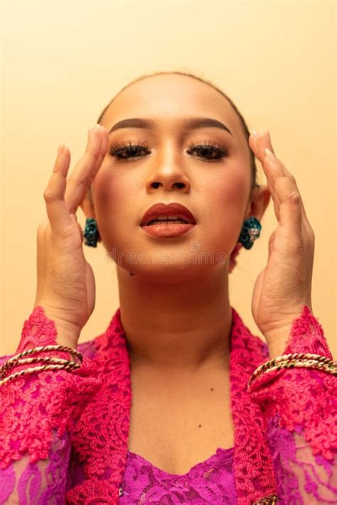 Beautiful Balinese Woman Wearing Makeup In A Pink Dress While Posing