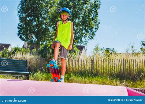 Lindo Y Feliz Chico De Patinaje Hace Trucos En El Parque De Patinaje Foto De Archivo Imagen De