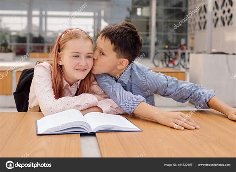 Две девочки целуются в школе на парте фото