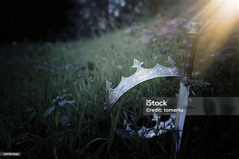 실버의 신비와 마법의 사진 킹 크라운 및 영국 숲에 있는 칼 또는 빛 플레어 프리 필드 중세 기간 개념입니다 개념에 대한 스톡
