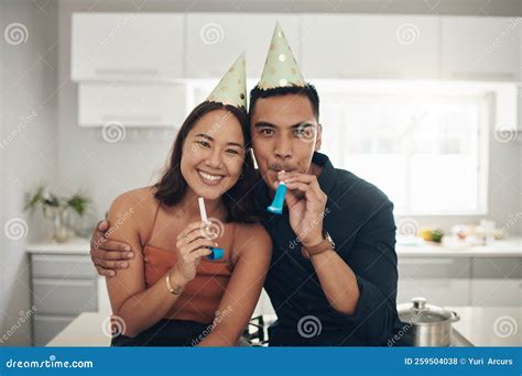 Time To Blow Your Party Horn A Young Couple Blowing Party Horns At