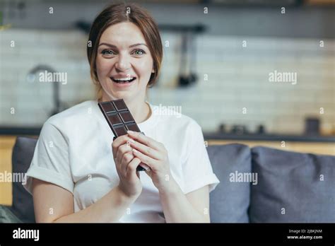 Portrait Of A Pregnant Woman Eating A Bar Of Delicious Chocolate