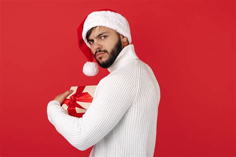 이상한 힙스터 남자는 빨간 배경 위에 선물 상자를 들고 산타 클로스 모자를 착용 크리스마스와 새해 개념 12월에 대한 스톡 사진 및 기타 이미지 Istock