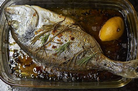 用迷迭香、柠檬和其他香草烤制的鱼。从上面的观点