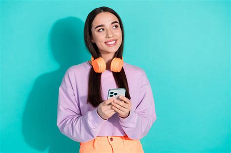 아름 다운 아가씨 모습 빈 공간 홀드 장치 헤드폰 옷 세련된 보라색 의류 아쿠아 마린 색상 배경에 고립 된 사진 Brand