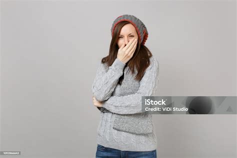 재채기 또는 기침 회색 스웨터 모자 스카프에 젊은 여자 입 팜 회색 배경에 절연 커버 건강 한 생활 습관 병 아픈 질병 치료