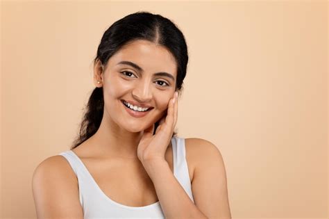 Premium Photo Shy Beautiful Indian Woman Touching Her Smooth Skin And Looking At Camera