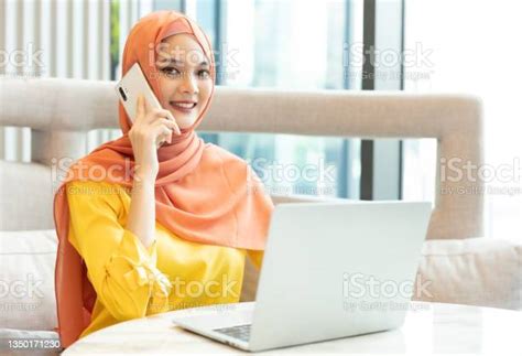 창의적인 협동에 앉아있는 동안 비즈니스와 미소를 논의 스마트 캐주얼 착용젊은 아시아 무슬림 비즈니스 여성 여자는 휴대 전화와 현대 사무실에서 노트북을 사용하여 이야기 25