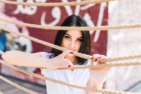 Young Beautiful Woman Inside A Ropes Looking Outdoors In Summer Street