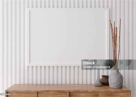 현대 거실의 흰색 벽에 빈 그림 프레임 미니멀한 스칸디나비아 스타일로 인테리어를 모의하세요 당신의 그림을위한 여유 공간 말린 식물이있는 나무 콘솔과 화병 3d 렌더링 0명에