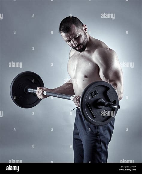 Man Doing Biceps Curl With Barbell In Studio Stock Photo Alamy