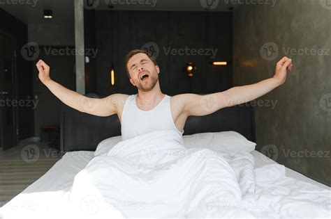 Young Man Sleeping Waking Up And Stretching In His Bed 47265852 Stock