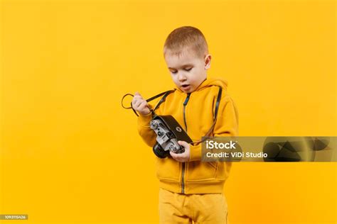 리틀 아이 보가 34 년 된 노란색 옷을 입고 오렌지 벽 배경 어린이 스튜디오 초상화에 고립 된 카메라를 개최 사람들이 진심으 감정 어린 시절 라이프 스타일 개념 복사