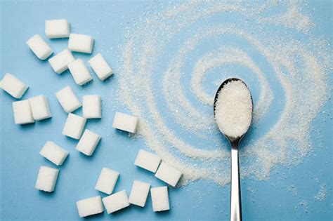 큐브 및 파스텔 파란색 배경에 숟가락 설탕 달콤한 음료 다이어트 Diebetes의 개념 정제 설탕 무료 상위 뷰 최소한의 평면