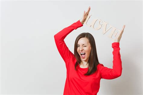 아름 다운 젊은 여자 그녀의 머리 나무 단어 위에 들고 캐주얼 옷에 사랑 하는 빨간색에서을 웃 고 흰색 배경 광고에 대 한 공간을 복사 합니다 성 발렌타인의 날 또는 국제