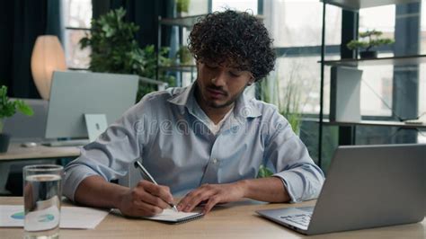 Arabian Indian Latin Man Businessman Guy Write Business Notes Ideas In Notebook Managing