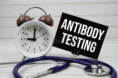 Antibody Testing Text Message On Paper Card With Stethoscope And Alarm Clock On Wooden