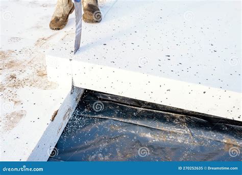 Builder Placing Polystyrene Insulation Boards On Waterproofing Membrane During Floor