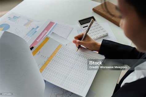 비즈니스 전략 계획을 위한 마케팅 지표로 종이에 재무 데이터 분석 대시보드를 작성하는 회계사 Office Of