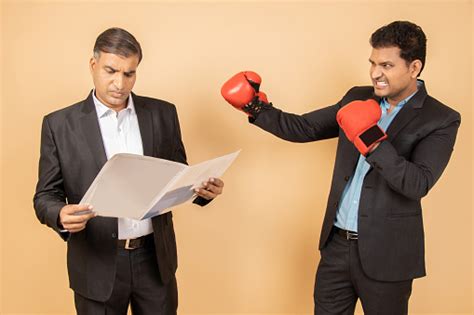 권투 글러브를 끼고 베이지색 배경에 고립된 확성기나 확성기로 상사나 고위 동료에게 주먹질을 하고 소리를 지르는 화난 인도 직원 2명에 대한 스톡 사진 및 기타 이미지