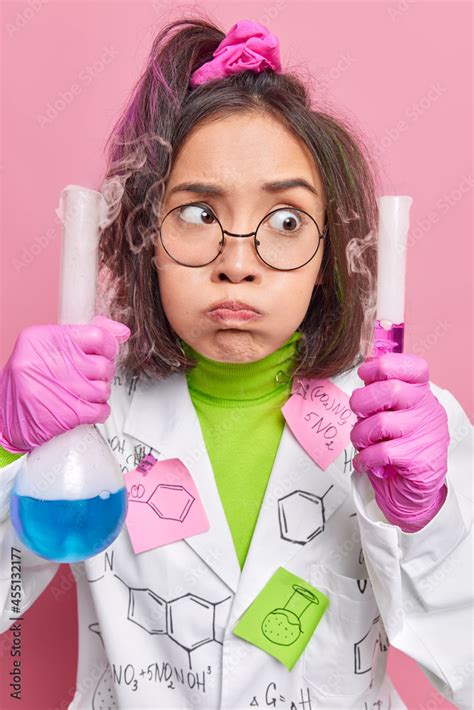Woman Chemist In White Medical Coat Conducts Experiment For First Time Holds Test Tube And Glass