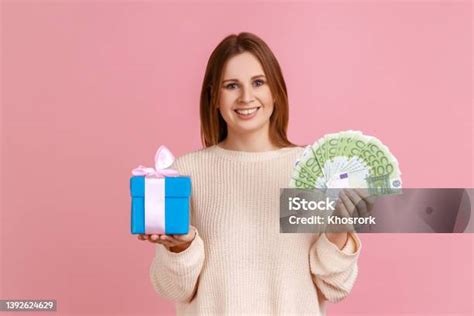 포장된 선물 상자와 유로 지폐를 들고 긍정적인 표정으로 카메라를 바라보는 여성 30 34세에 대한 스톡 사진 및 기타 이미지 30 34세 Championship 고객