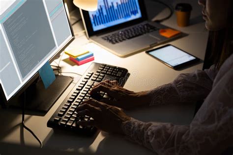 hands of biracial female programmer sitting at desk using computer