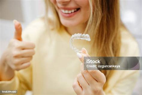 치과용 보이지 않는 교정기 또는 실리콘 트레이너는 젊은 웃는 여성의 손에 있습니다 교정 개념 인비절라인 이빨에 대한 스톡 사진 및 기타 이미지 Istock