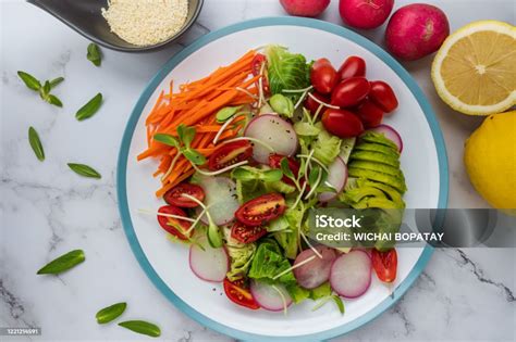 건강한 비건 그릇 아보카도 토마토 붉은 무 당근 해바라기 묘목 후추 레몬 야채 샐러드 맨 위 보기 비건 음식 깨끗한 식사