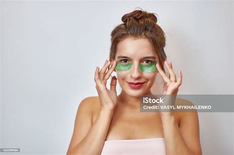 소녀는 눈 아래에 콜라겐 하이드로겔 패치를 사용합니다 아름다움 개념 눈 주위의 피부 관리를 위한 화장품 리프팅 미용실 주름 제거