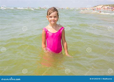 The Girl In The Pink Bathing Suit Standing In The Water Of The Sea