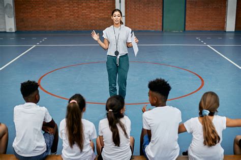 Joven Profesor De Deportes Comunicándose Con Un Grupo De Niños De La