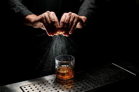 어두운 배경에 칵테일을 위해 오렌지 껍질에서 오일을 표현하는 남자 바텐더의 손 감귤류 과일에 대한 스톡 사진 및 기타 이미지