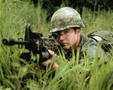 A Us Army Soldier Aims An M16a1 Rifle Equipped With An M203 Grenade