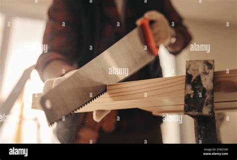 Construction Worker Renovating A Homes Interior Kitchen Using A Crosscut Saw He Cuts A Wooden