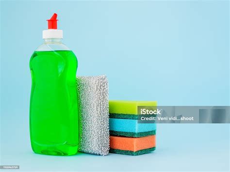 녹색 식기 세척액이있는 투명 한 병과 파란색 배경에 다른 색상의 4 개의 거품 스폰지 공간을 복사합니다 부엌 세제 가정용 화학 물질 0명에 대한 스톡 사진 및 기타 이미지