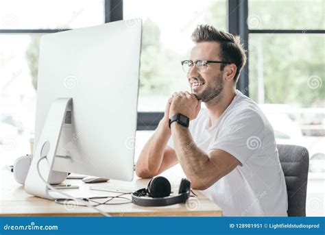 Smiling Young Programmer In Eyeglasses Using Desktop Computer Stock