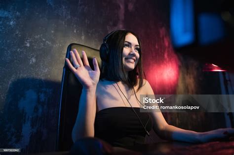 귀여운 여성 게이머 여자는 컴퓨터 뒤에 아늑한 방에 앉아서 게임을 재생 라이브 스트리밍 그녀의 팬 들에 게 컴퓨터 비디오 게임 및 그들에 게 손을 흔드는 여자 스 트리머와