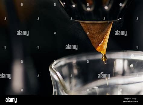 Close Up View Of Espresso Dripping From Paper Filter On Dripper Stand