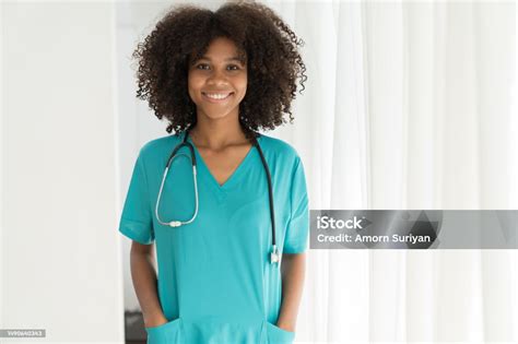 파란색 수술복을 입고 청진기를 착용하고 병원에 서 있는 젊은 여성 의사 하얀 배경에 서 있는 아프리카계 미국인 젊은 간호사 20 24세에 대한 스톡 사진 및 기타 이미지