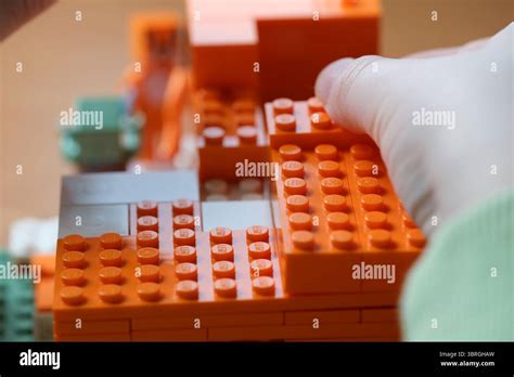 Hands Skillfully Assemble Vibrant Blocks In A Playful Construction