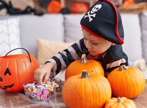 Adorable Caucasian Boy Wearing Pirate Costume Holding Sweet At Home