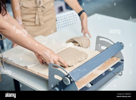 Female Working Potter Rolling Out Clay Slabs In Her Pottery Studio