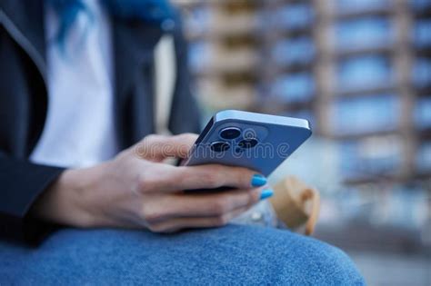 Young Woman Browsing Mobile App On A Modern Blue Smartphone