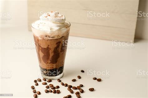 유리에 아이스 커피 커피 콩 휘핑 크림을 얹어 나무 배경과 복사 공간에 차가운 여름 음료 카페카라멜 모카와 초콜릿 음료 광고 0
