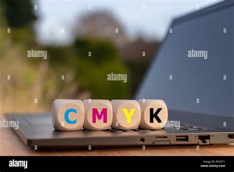 Symbol For The CMYK Color Model Dice Placed On A Notebook With The Letters CMYK With
