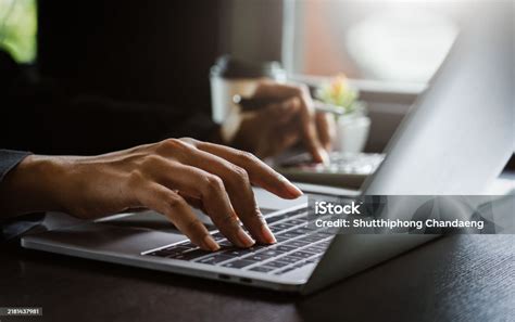 사무실 환경에서 원격으로 작업하는 동안 노트북 키보드로 타이핑하는 손의 클로즈업으로 전문적인 작업 환경에서 집중력 기술 및 효율성을 강조합니다 Brand Name Smart