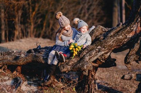 Premium Photo Full Length Of Cute Siblings By Tree Trunk Outdoors